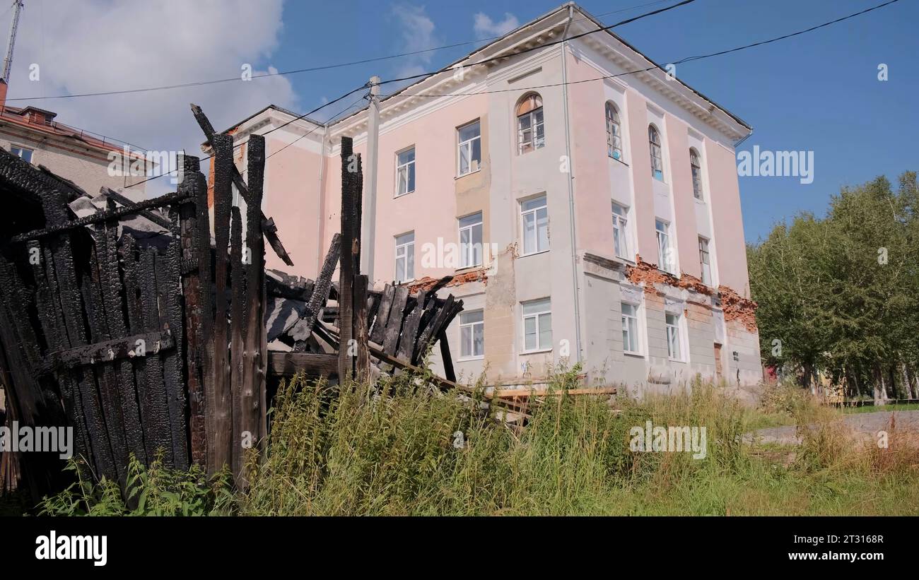 View of an old abandoned house with fallen plaster. Clip. Green grass ...