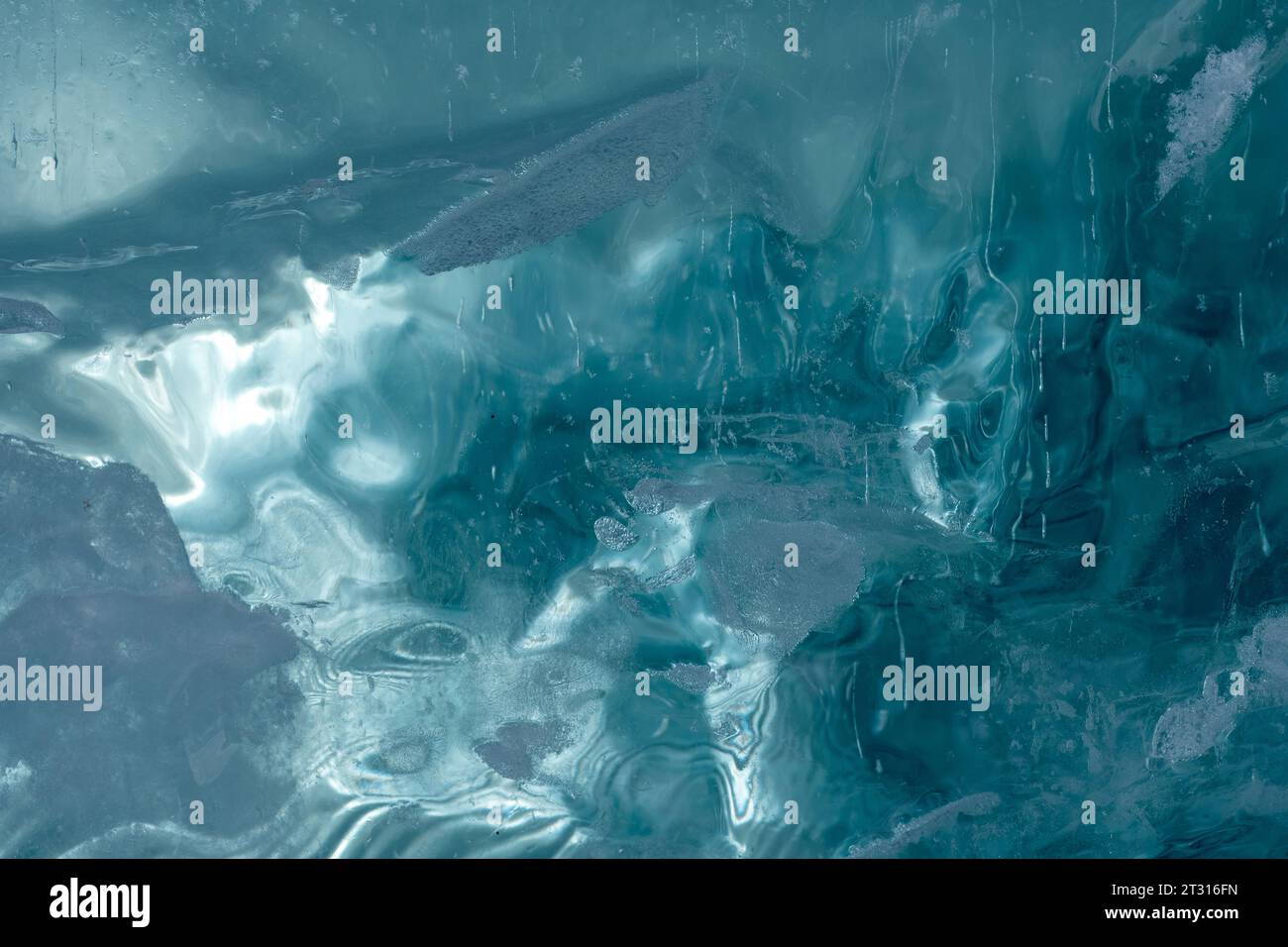 Texture of frozen ice of a mountain lake. The thickness of green-blue ...