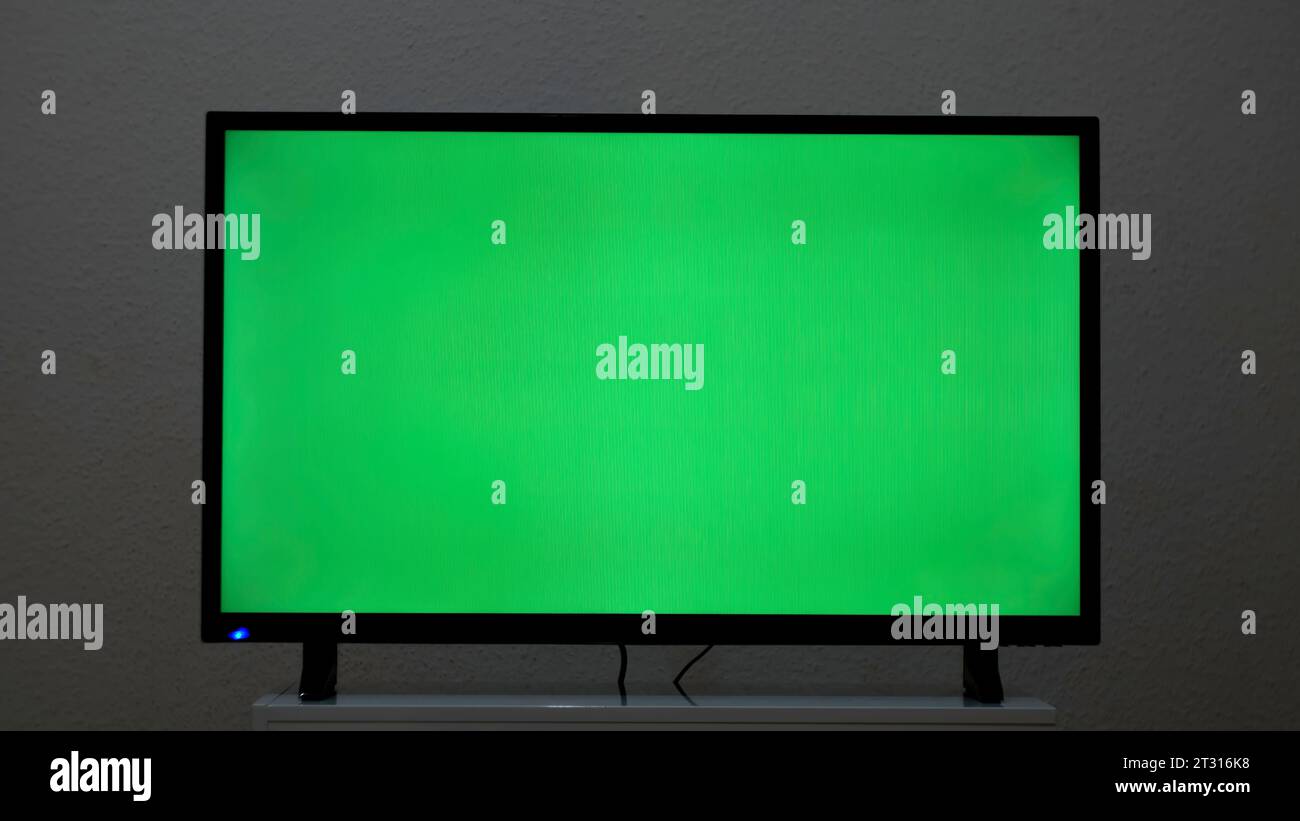 LcD smart TV with green screen on a grey wall background in the living ...