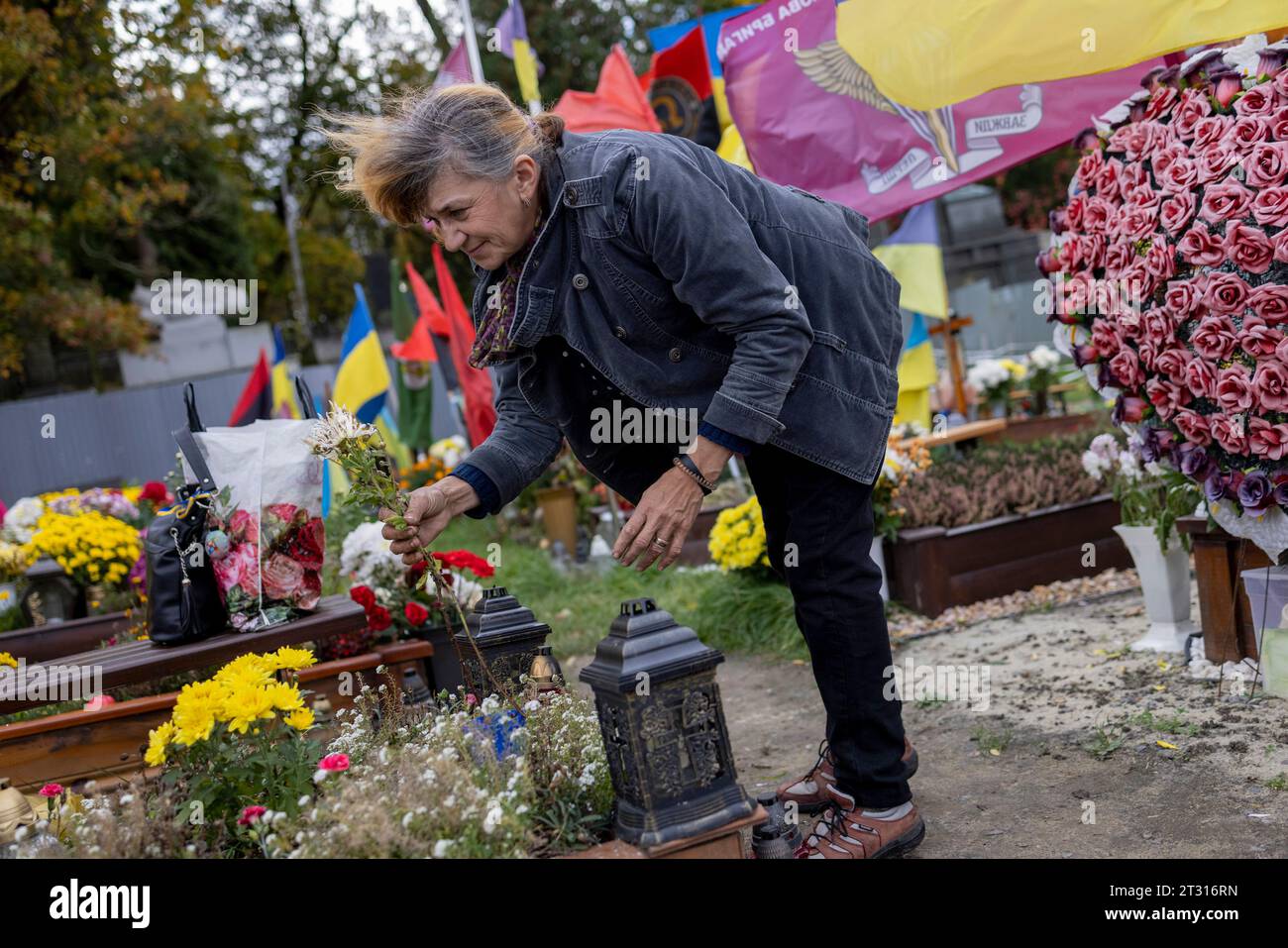 A relative of a fallen soldier seen tidying the flower tributes on the ...