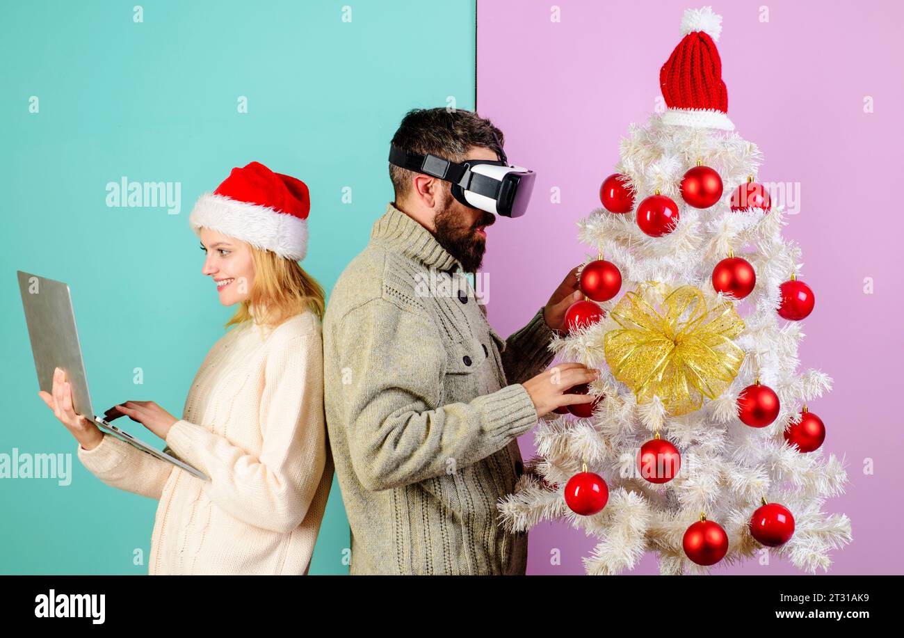 Christmas couple. Bearded man in VR glasses and smiling woman in Santa ...