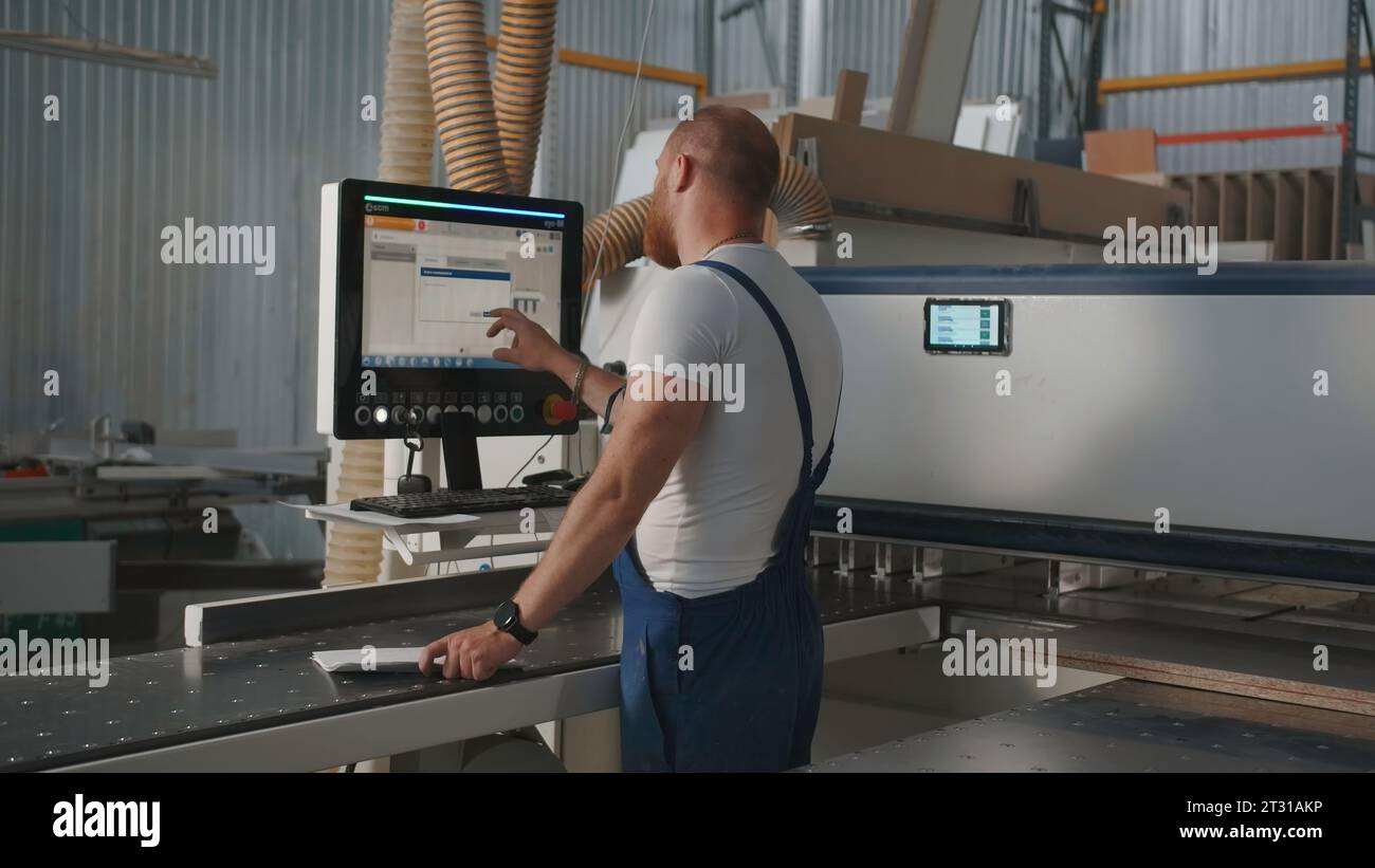 Man clicks on control panel. Creative. Man with beard in work uniform ...