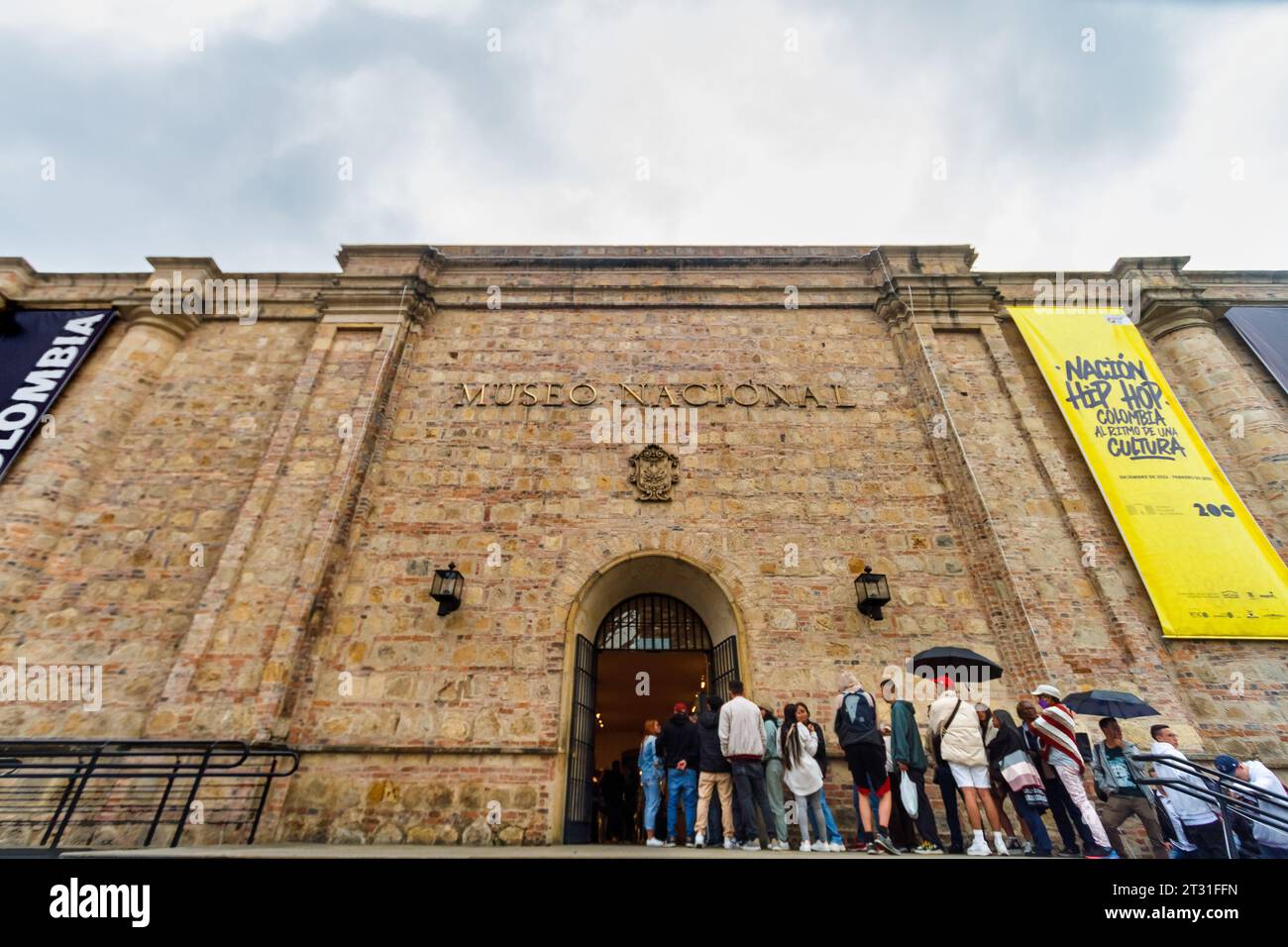 Bogota, Colombia - January 8, 2023: People line up in the rain to enter ...