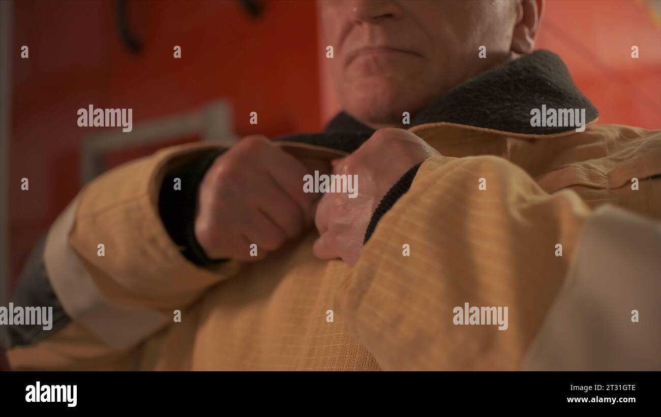 Firefighter puts on work uniform. Clip. Man zips up fire uniform and ...