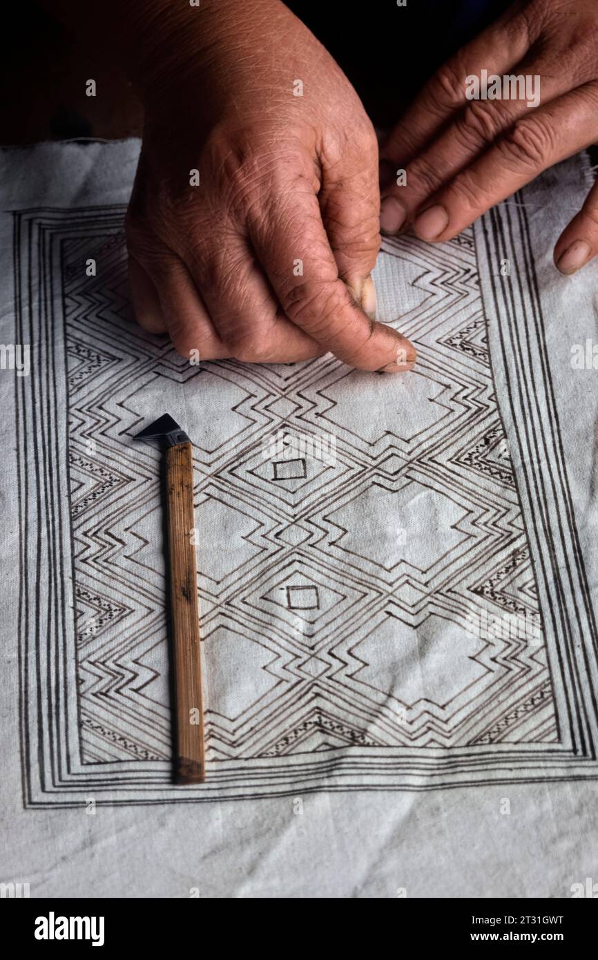 A Flower Hmong woman draws a pattern for her traditional embroidery, Mu ...