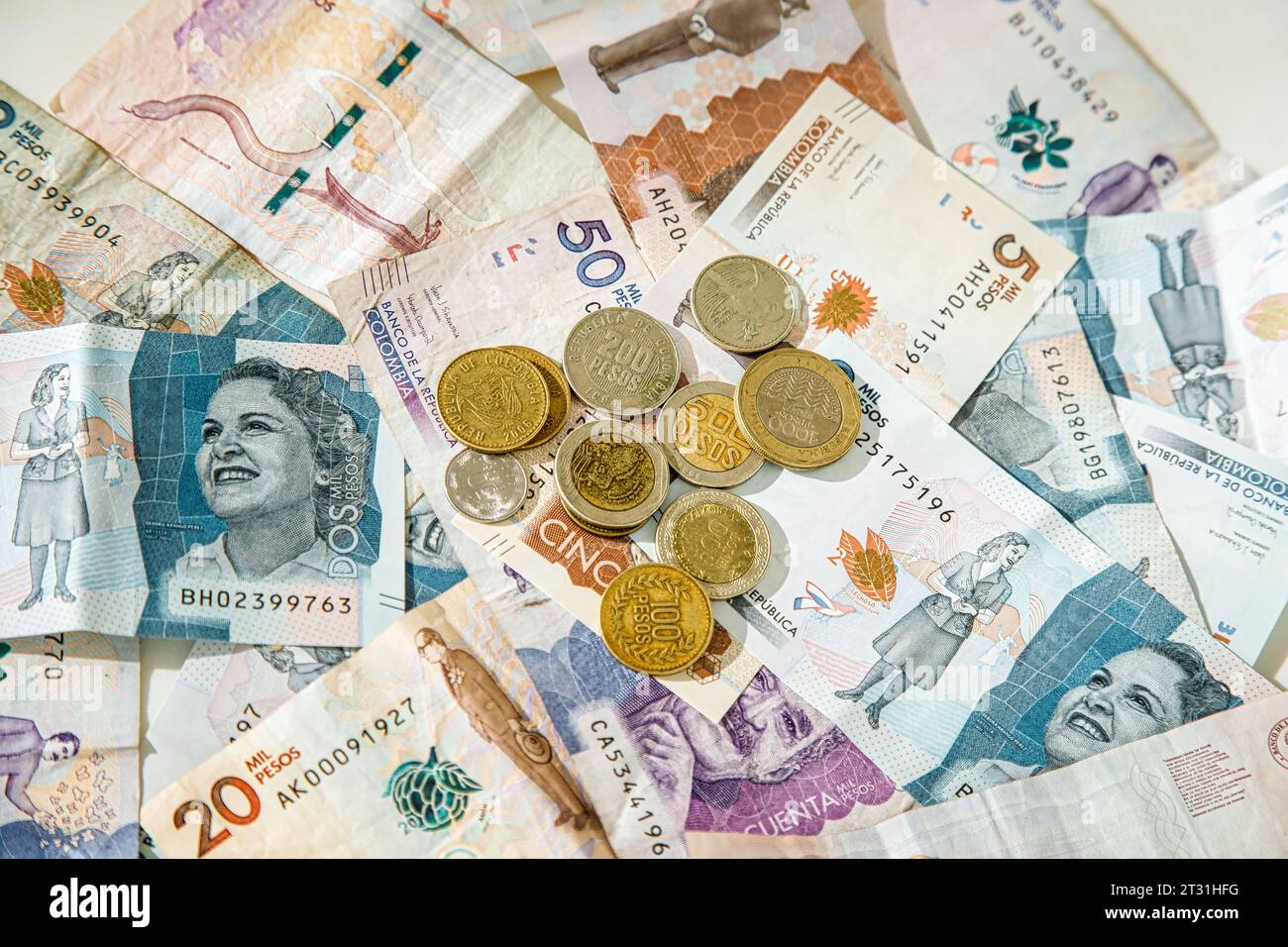 Macro closeup of Colombian peso coins on banknotes of different ...