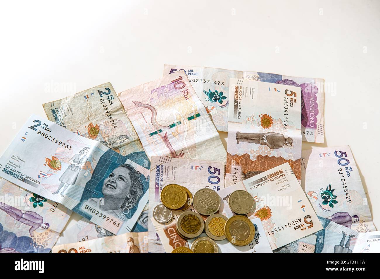 Macro closeup of Colombian peso banknotes and coins on white background ...