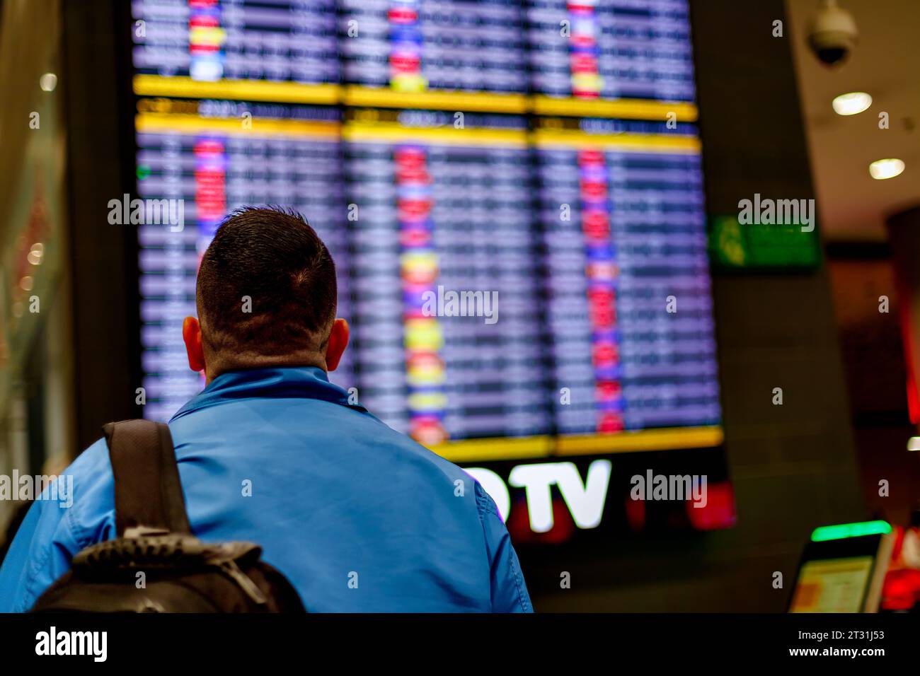 Passenger checks his flight in front of the arrivals and departures ...