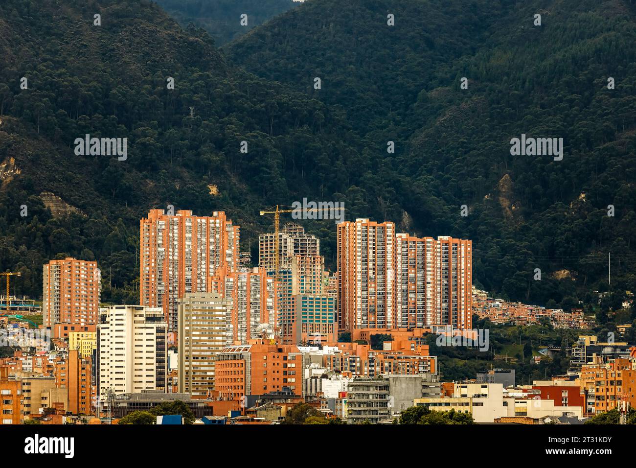 Residential buildings with one under construction at the foot of a hill ...