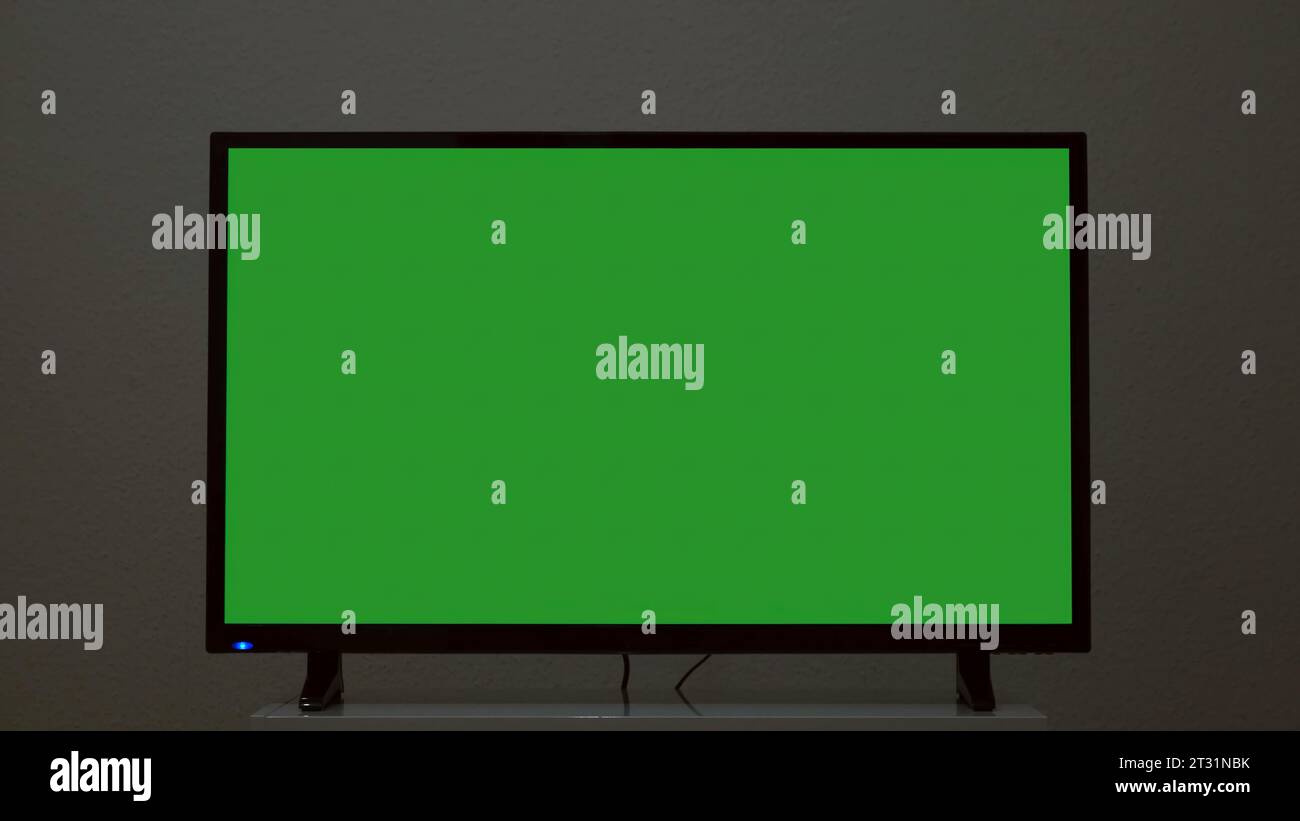 Plasma TV with green screen stands on background wall. Concept. Green ...