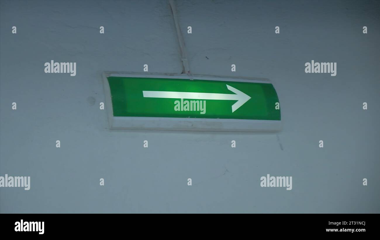 Glowing green arrow on wall. Clip. Arrow on green background lights up ...