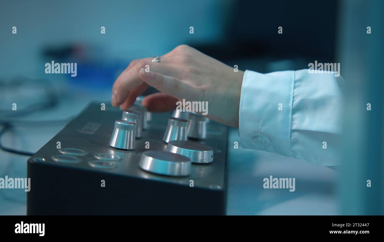 Close-up of woman rotating buttons on equipment control panel. Stock ...