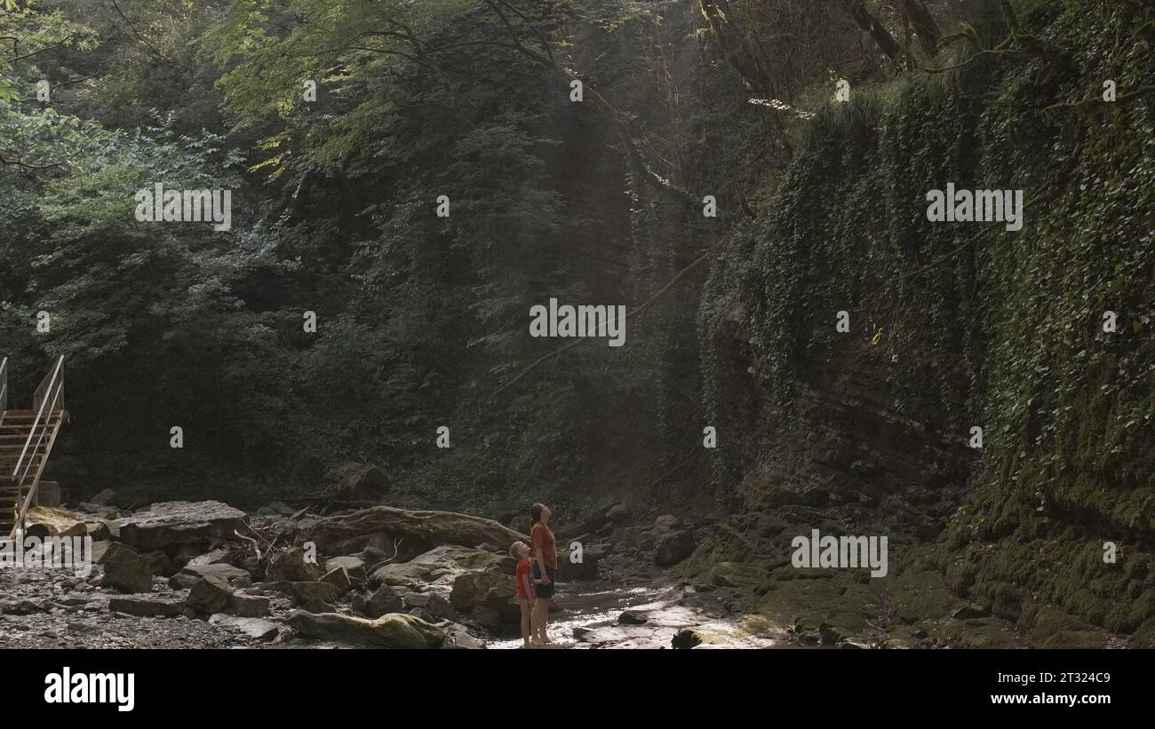 Mother and child look at rocks in forest in summer. Creative. Mother ...