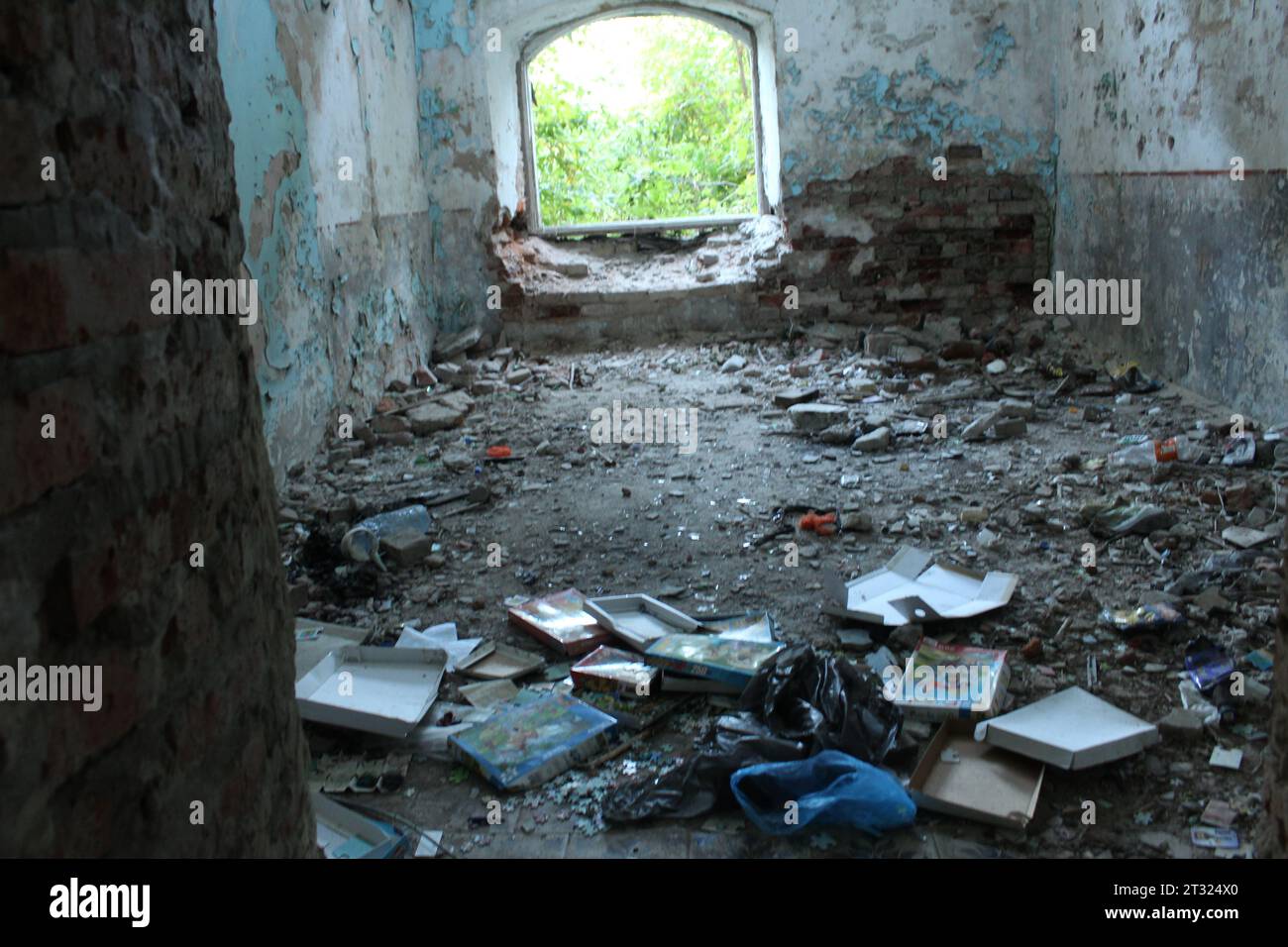 An abandoned ruined room with fragments of a wall of bricks. The ...