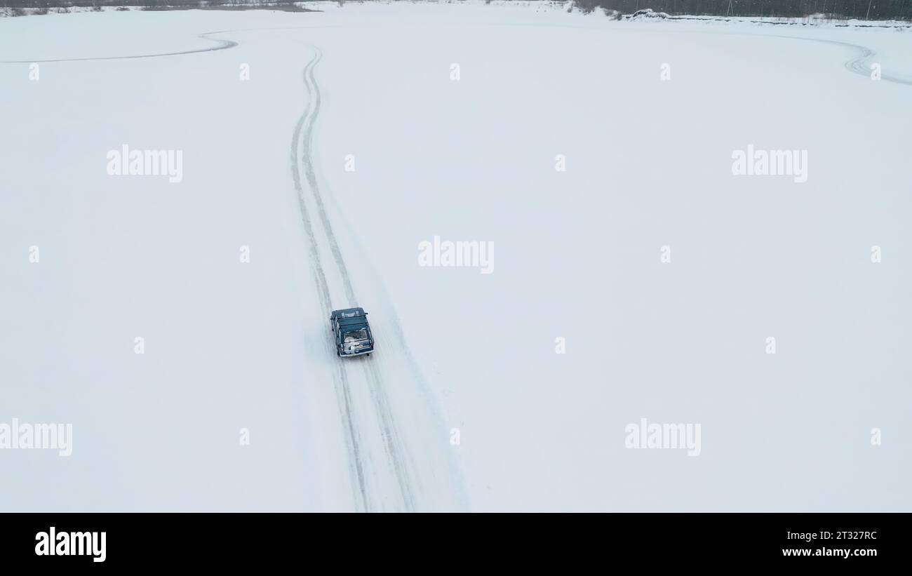 Cars on a frozen track on a lake with snow. Clip. Aerial view of winter ...