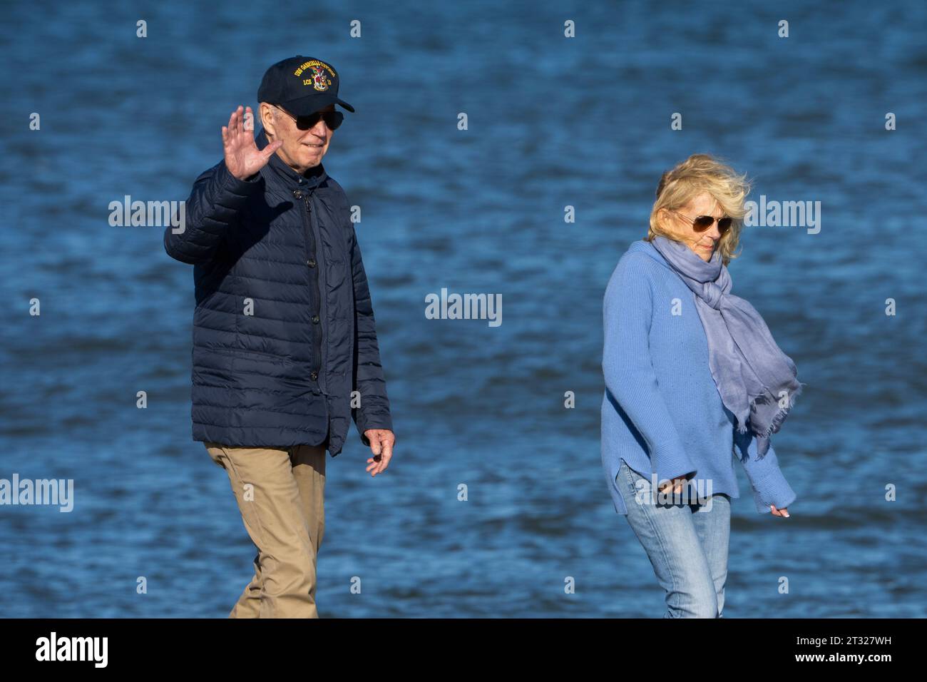 President Joe Biden with first lady Jill Biden waves as they walk along ...
