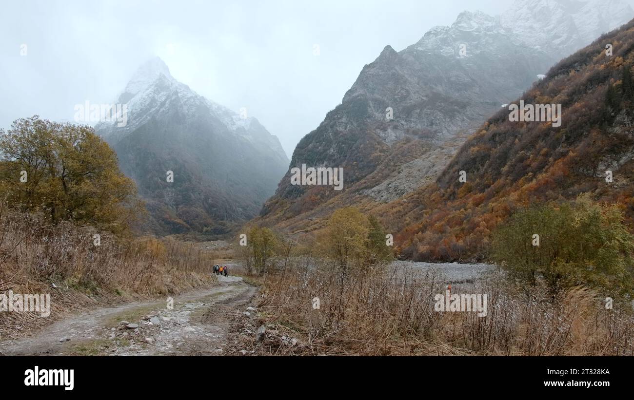 Hikers walking along the path near autumn scenery. Creative. Exploring ...