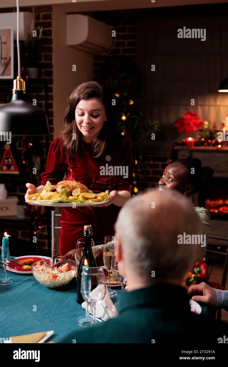 Woman putting festive food on table, enjoying christmas dinner and ...