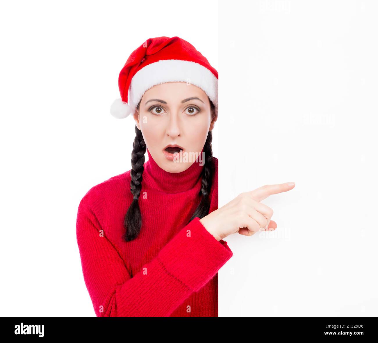 Surprised Woman in Santa Hat pointing with her finger on banner ...