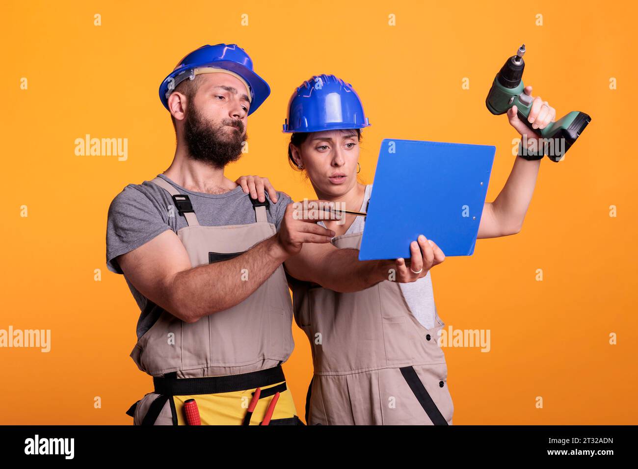 Team of construction workers analyzing papers on clipboard, taking ...