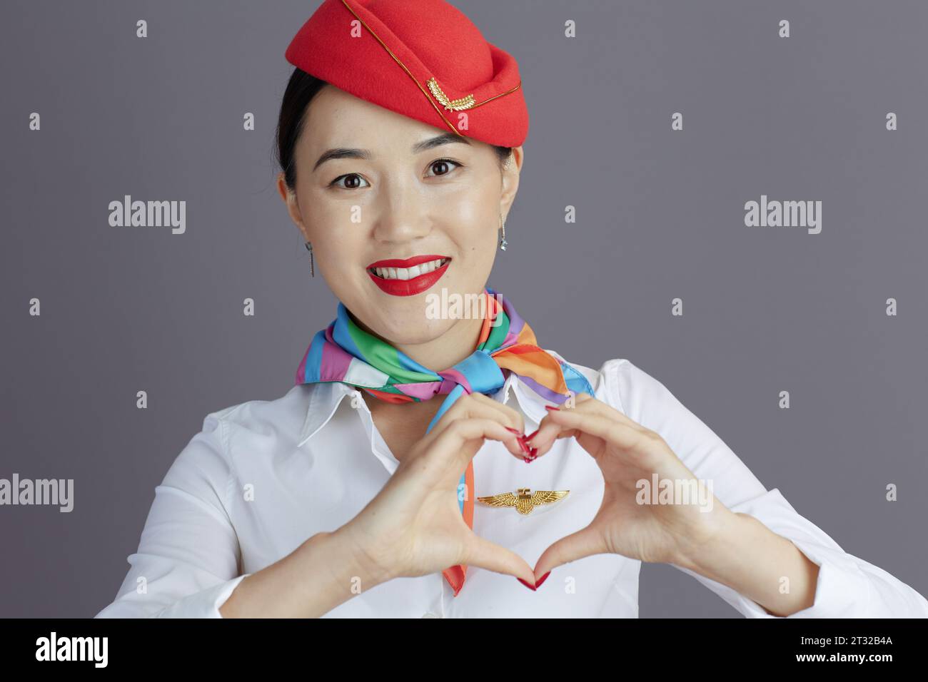 smiling modern asian female stewardess in red skirt and hat uniform ...
