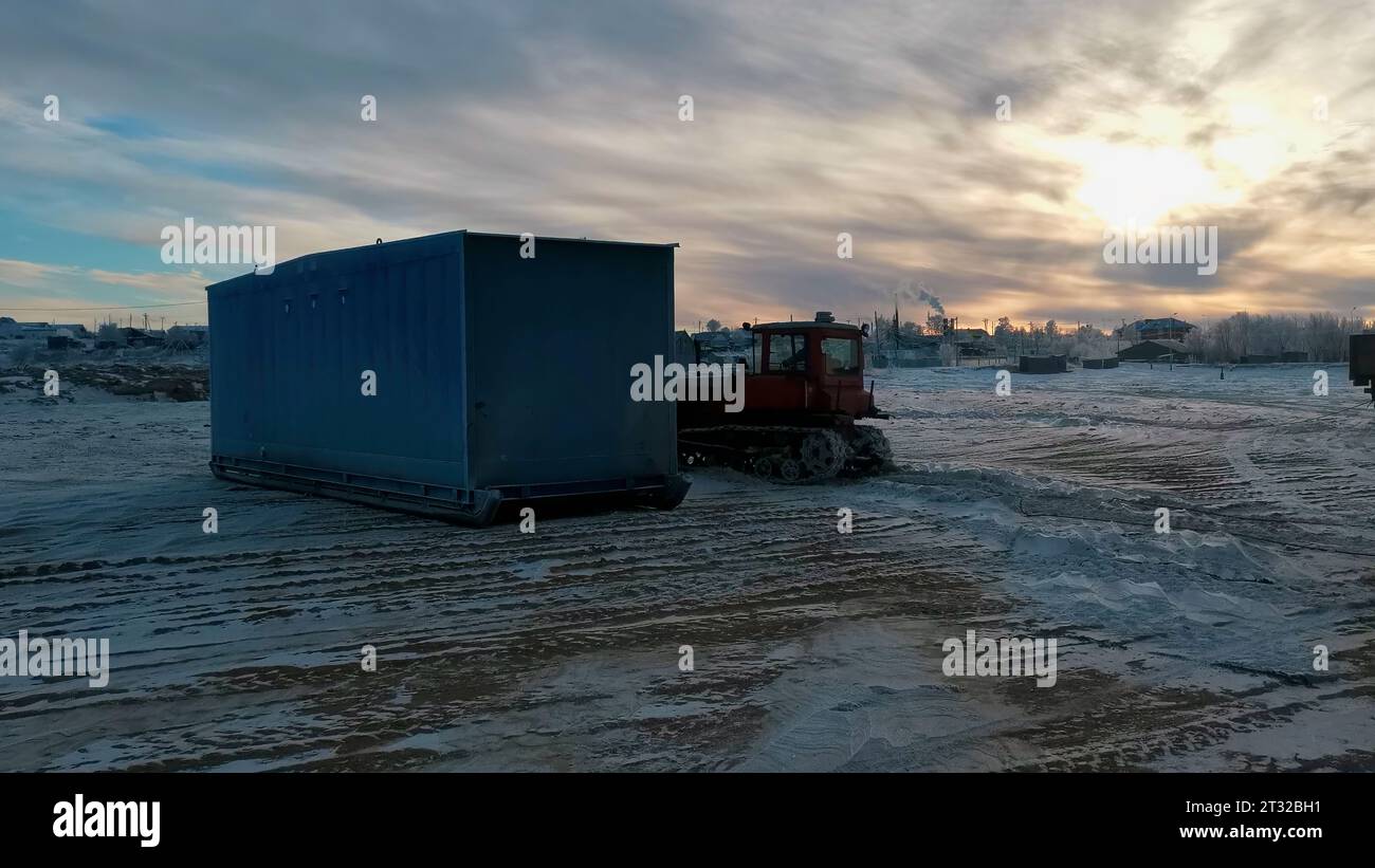Transporting containers with goods with a tractor. Clip. Winter field ...