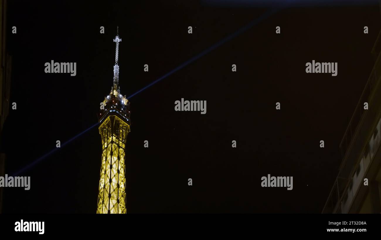 Low angle view of a shining illuminating tower on the night sky ...