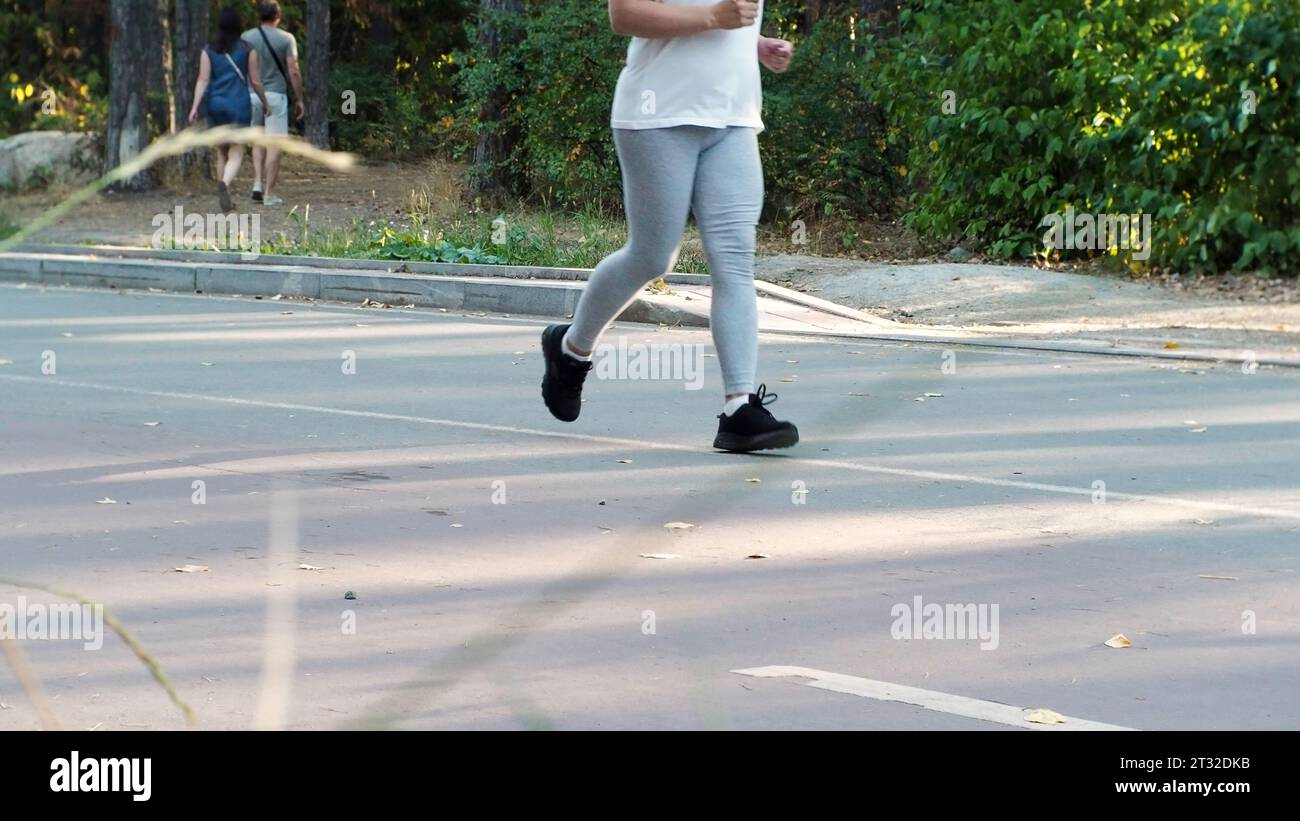 Sportsman in active wear running along green forest. Motion. Young ...