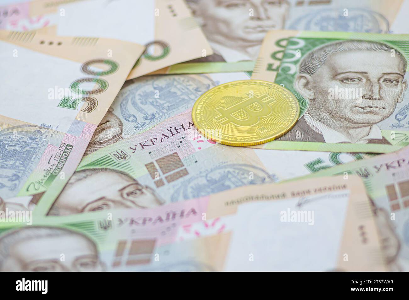 Golden bitcoin on five hundred ukrainian hryvnia bills background ...