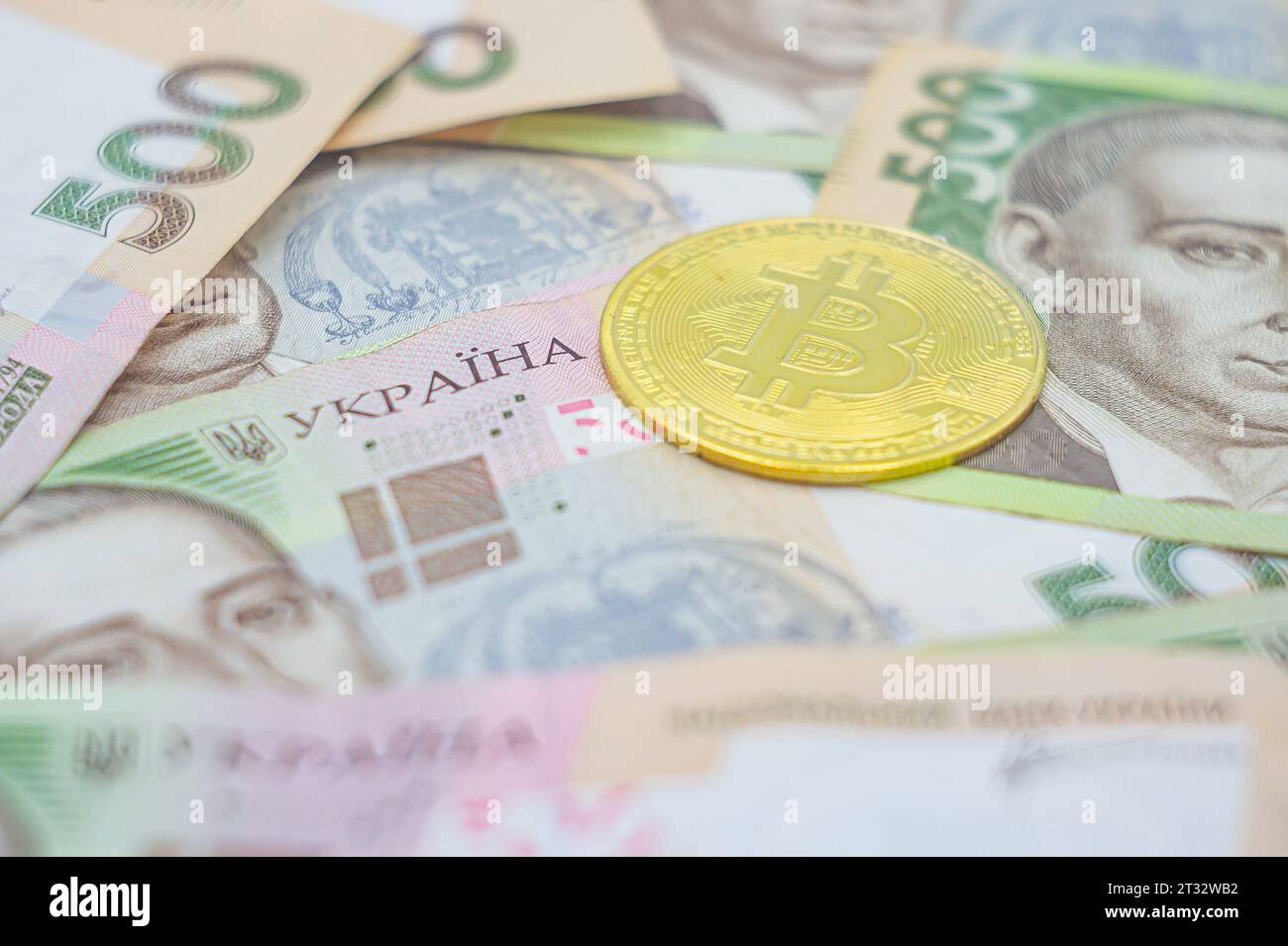 Golden bitcoin on five hundred ukrainian hryvnia bills background ...