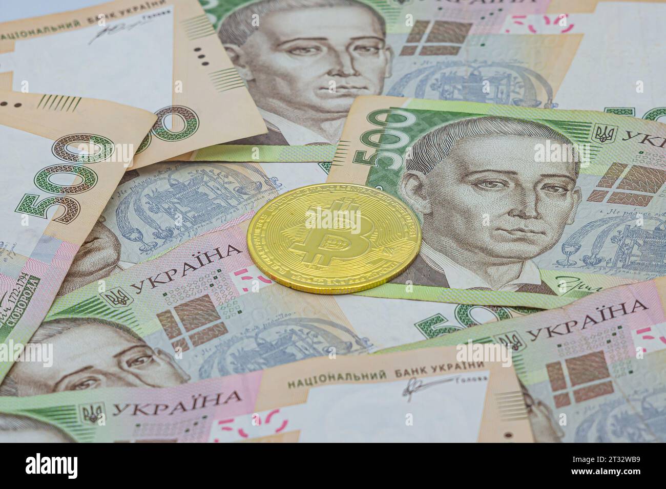Golden bitcoin on five hundred ukrainian hryvnia bills background ...