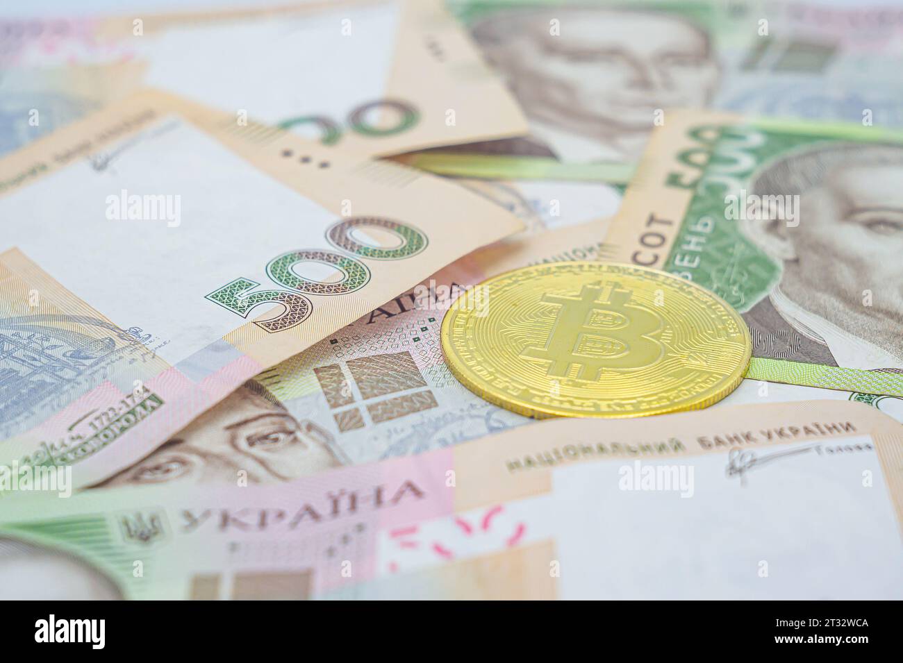 Golden bitcoin on five hundred ukrainian hryvnia bills background ...