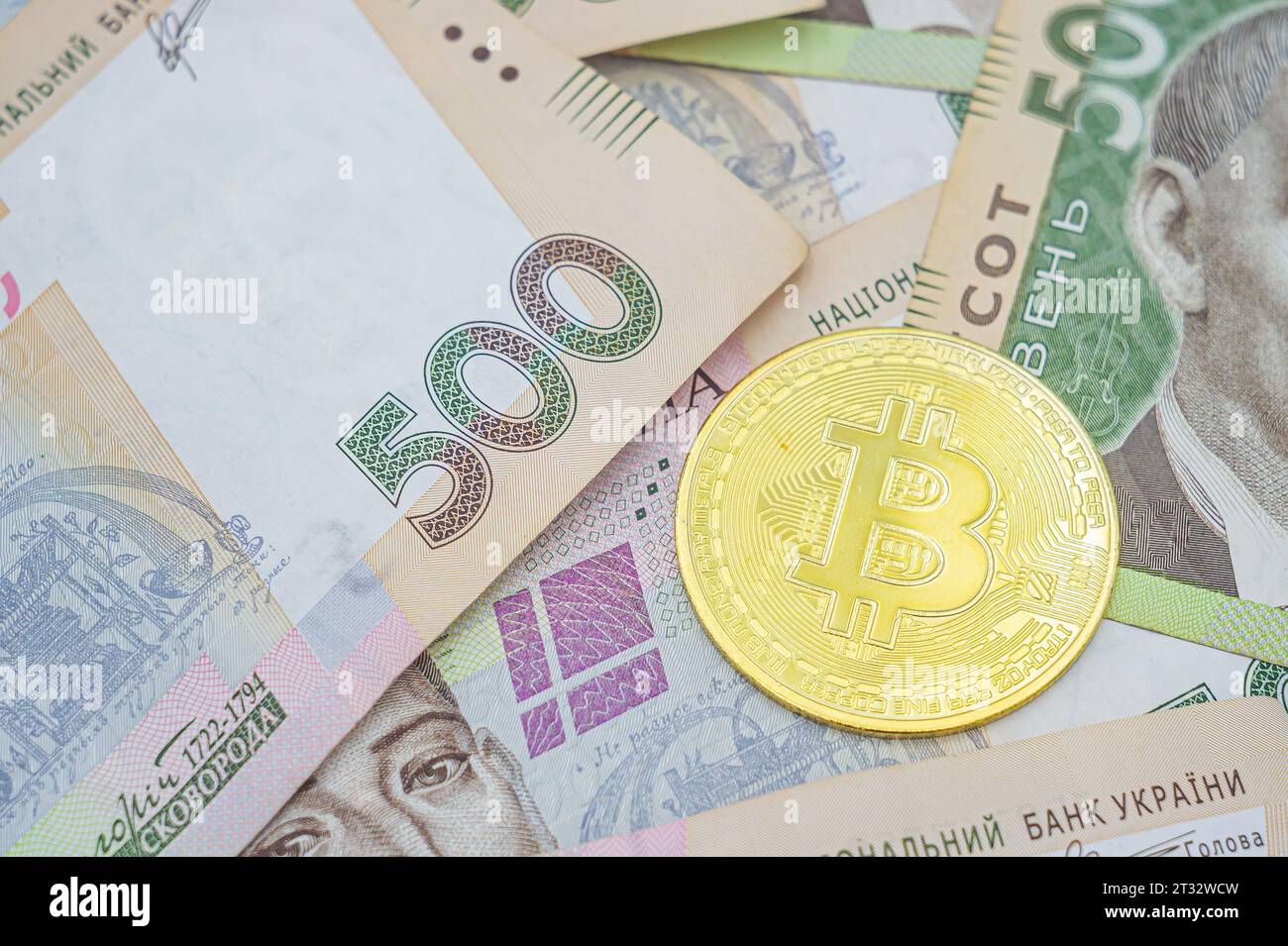 Golden bitcoin on five hundred ukrainian hryvnia bills background ...