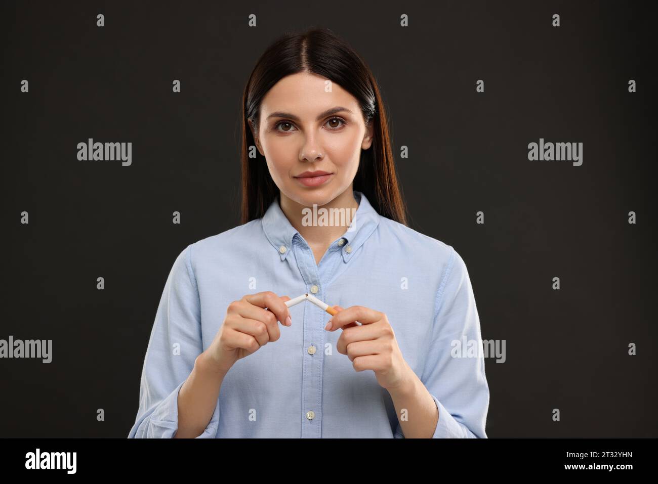 Stop smoking concept. Woman breaking cigarette on black background ...