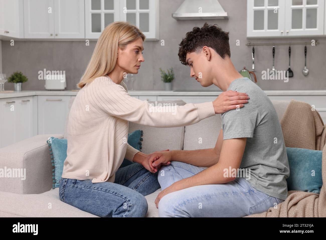 Mother consoling her upset son at home. Teenager problems Stock Photo ...