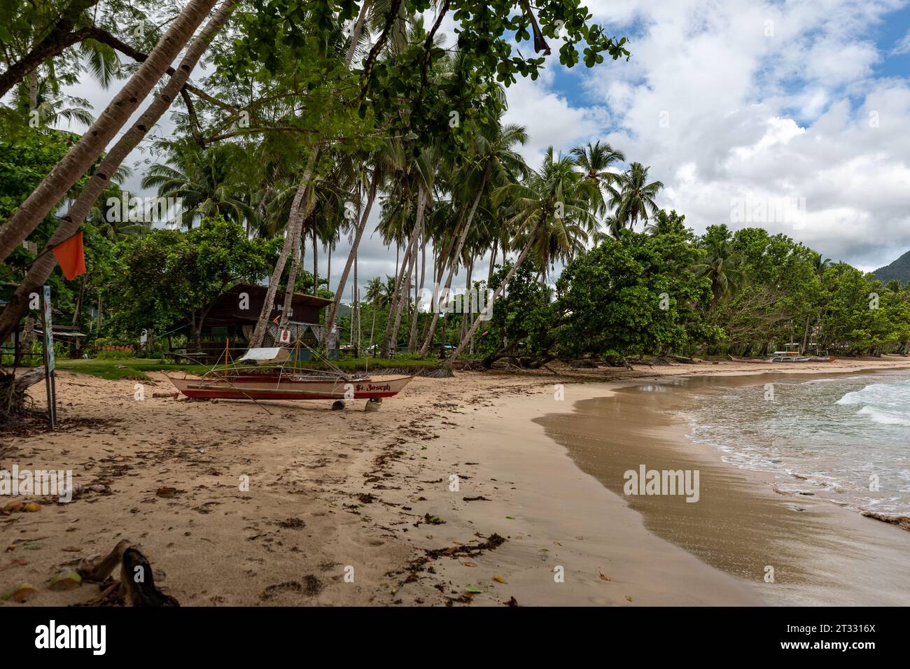remote tropical beach and jungle with traditional Filipino banca boat ...