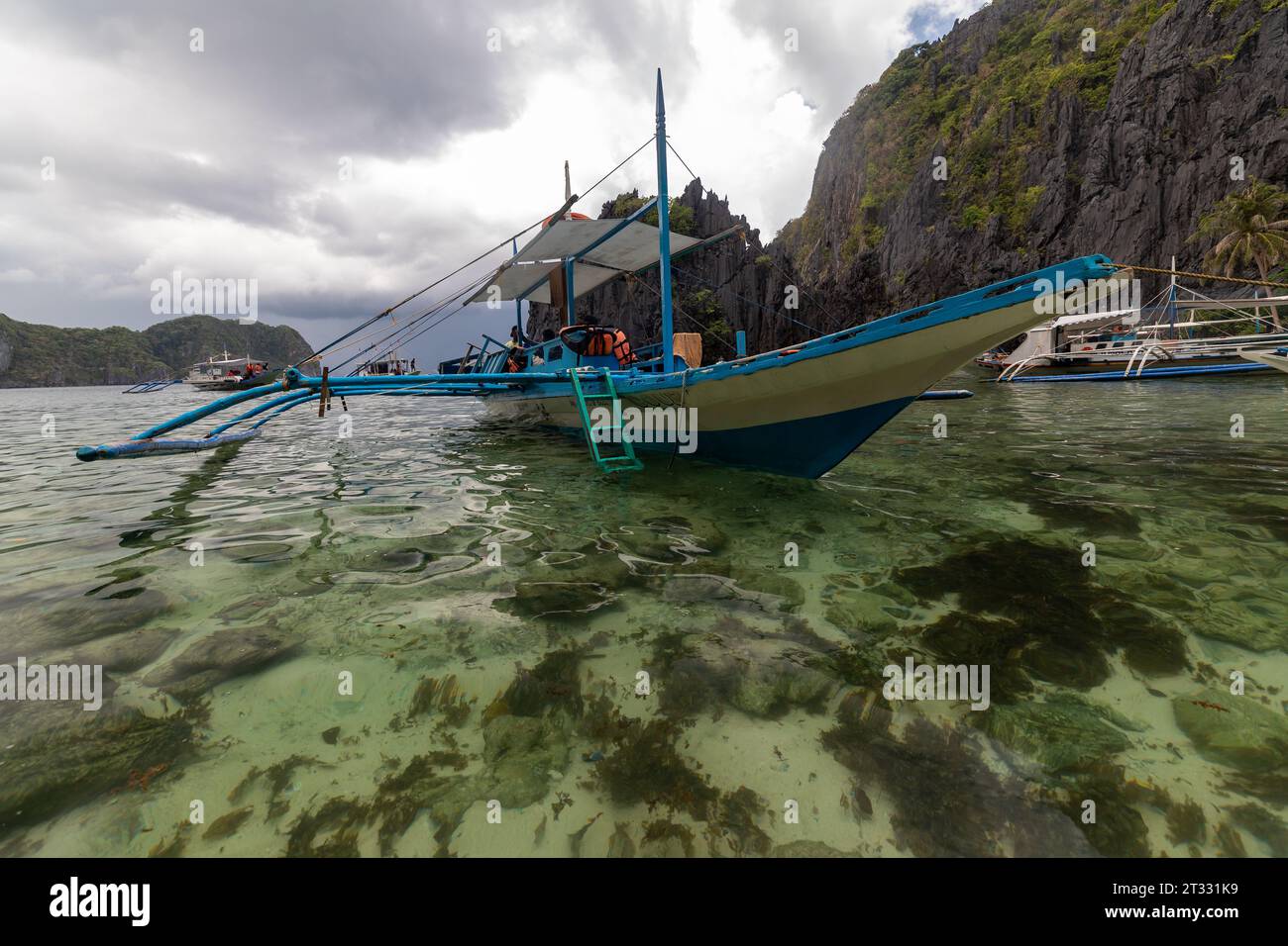 Traditional Filipino banca boats with outriggers anchored in hidden ...