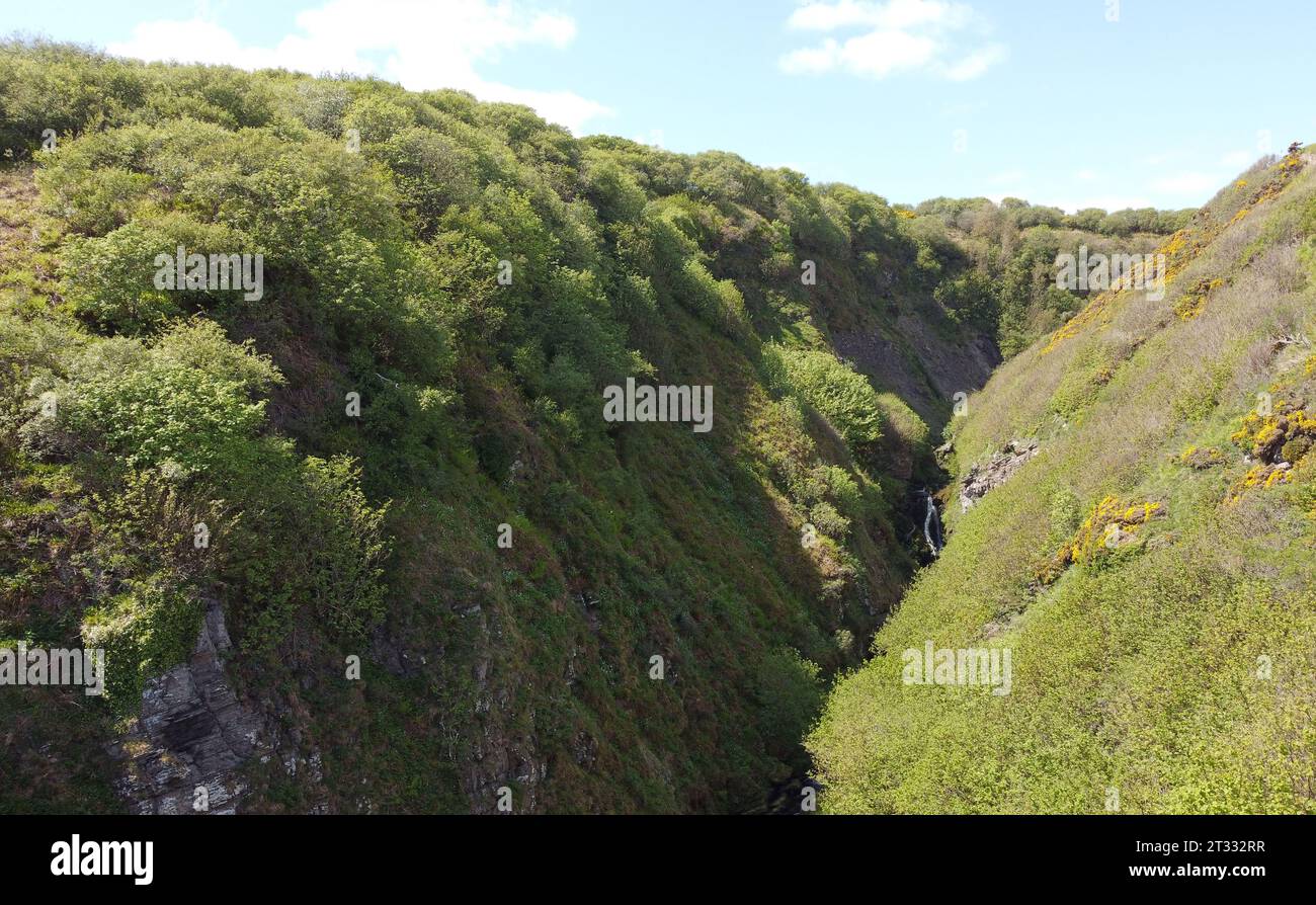 A picturesque landscape featuring a dramatic hillside with a winding ...