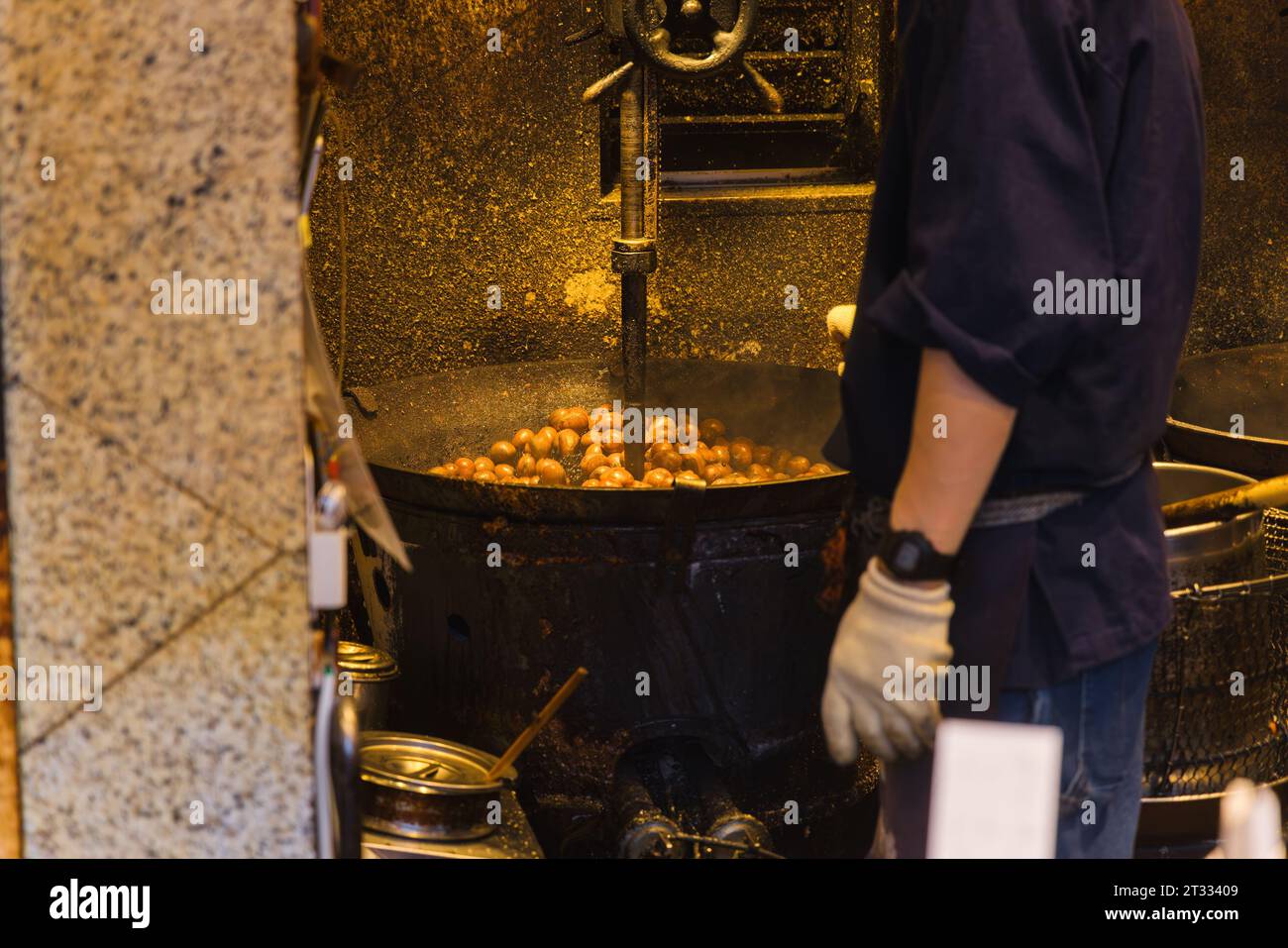 picture of a man at a street food stand roasting chestnuts in an old ...