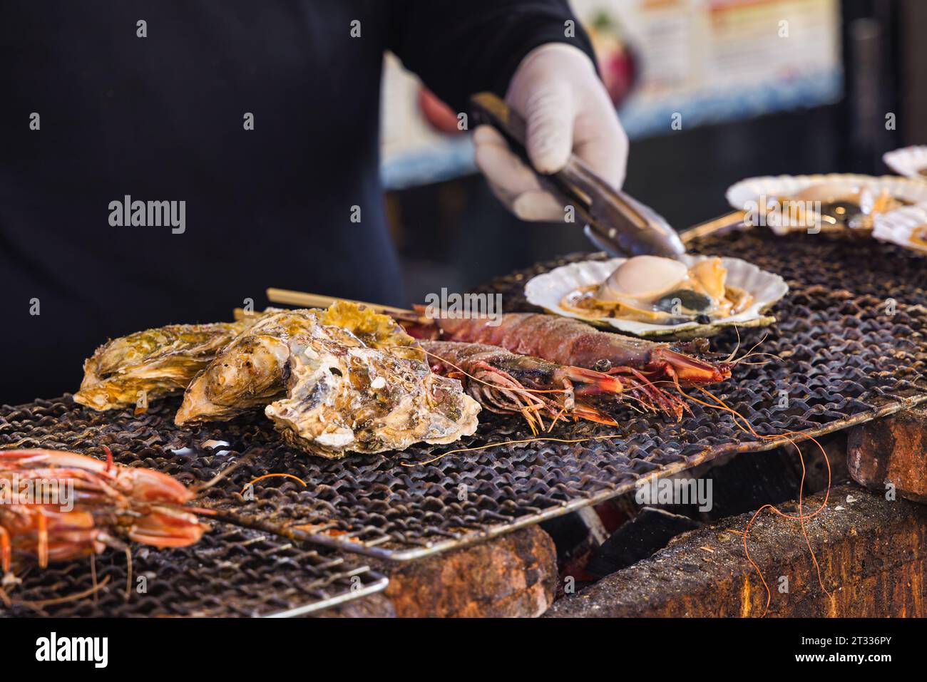 A chef at a street kitchen on the famous fish market Tsukiji in Tokyo ...
