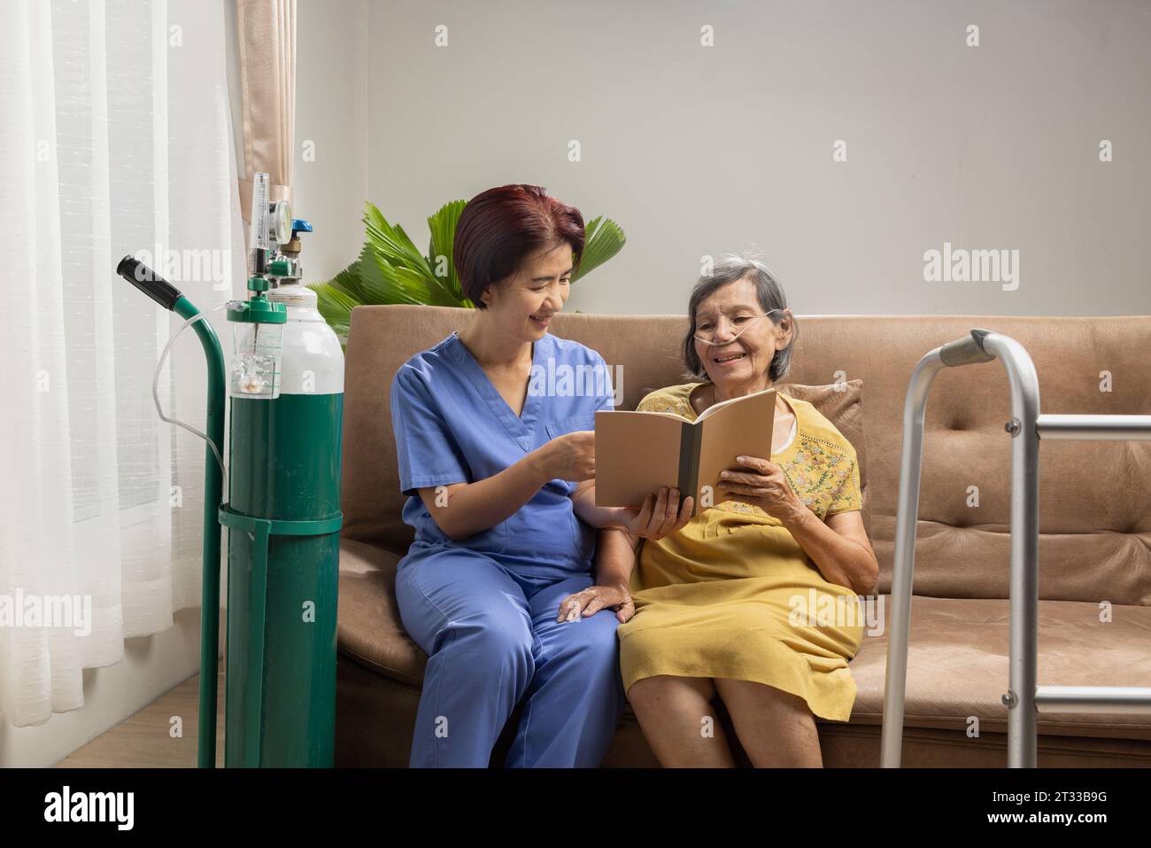 Caregiver takecare elderly woman while wearing oxygen nasal cannula at ...