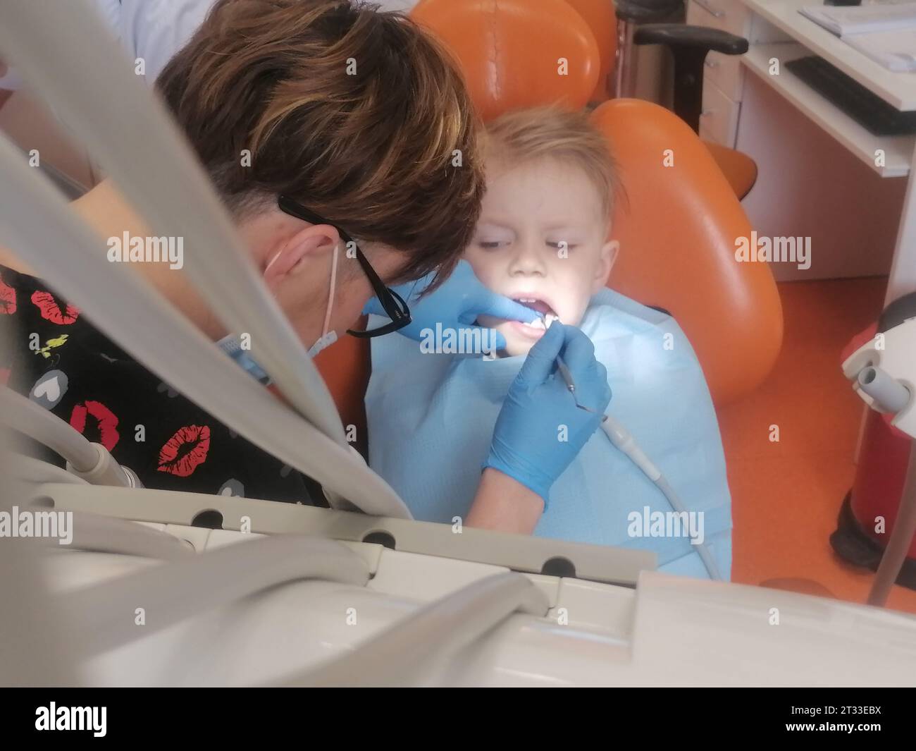 Female dentist examines the teeth of the patient cheerful child with ...