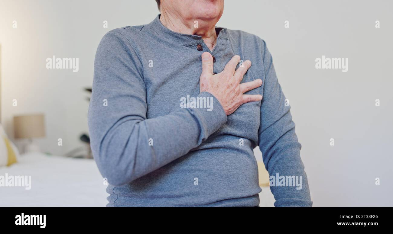 Hands, chest pain and closeup of elderly man in bedroom with injury ...