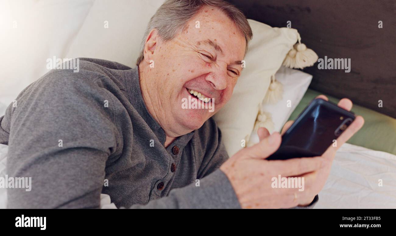 Happy, senior man and reading with phone in bed or streaming funny ...