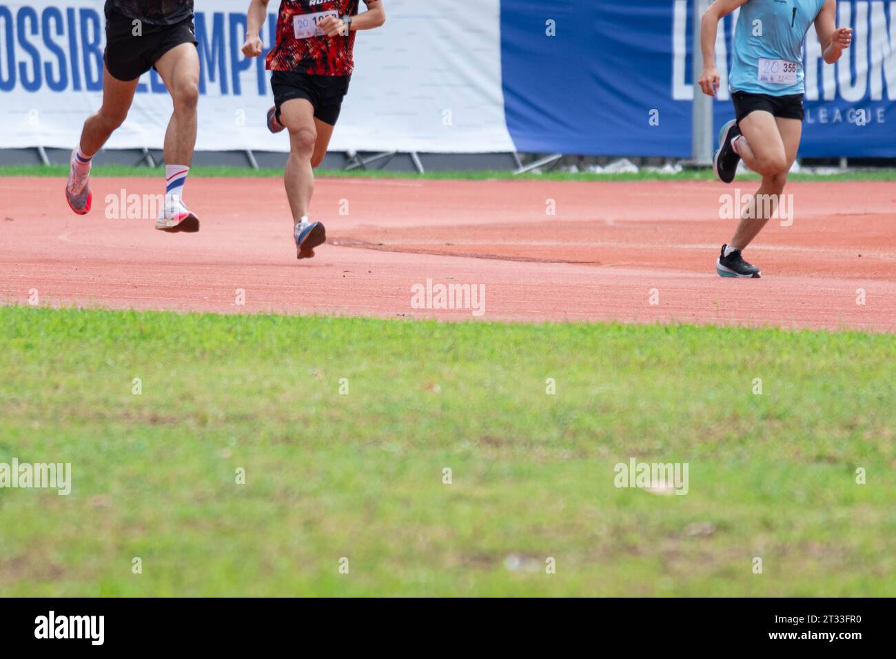 The feet of an athlete running outdoors at the racetrack. Fit young man ...