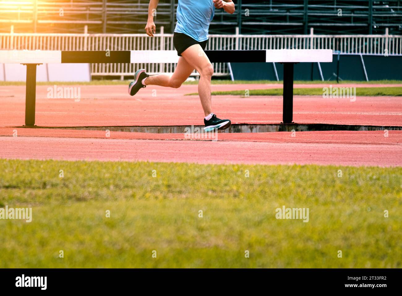 The feet of an athlete running outdoors at the racetrack. Fit young man ...