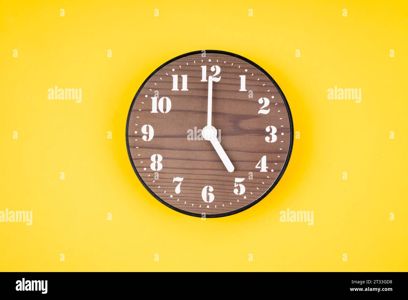 Retro wooden clock at 5 O' clock on yellow color background Stock Photo ...