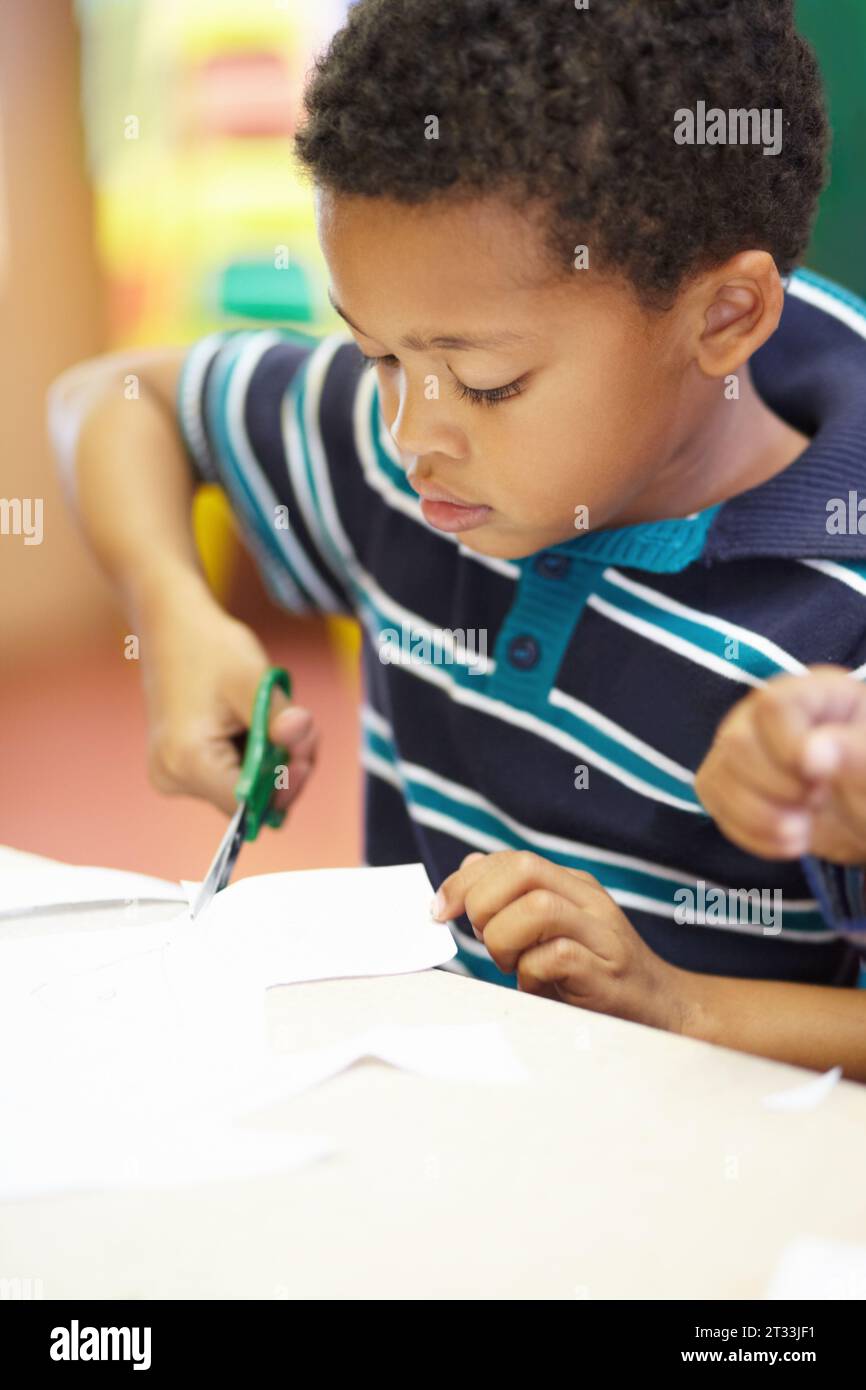 Boy, classroom and scissor for cutting paper with learning, thinking ...