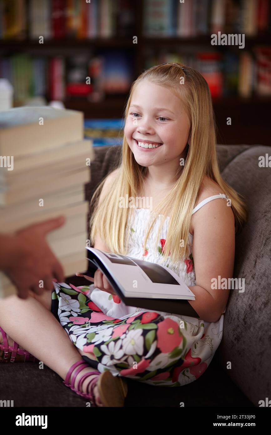 Reading, stack of books and child in library with smile, learning and ...