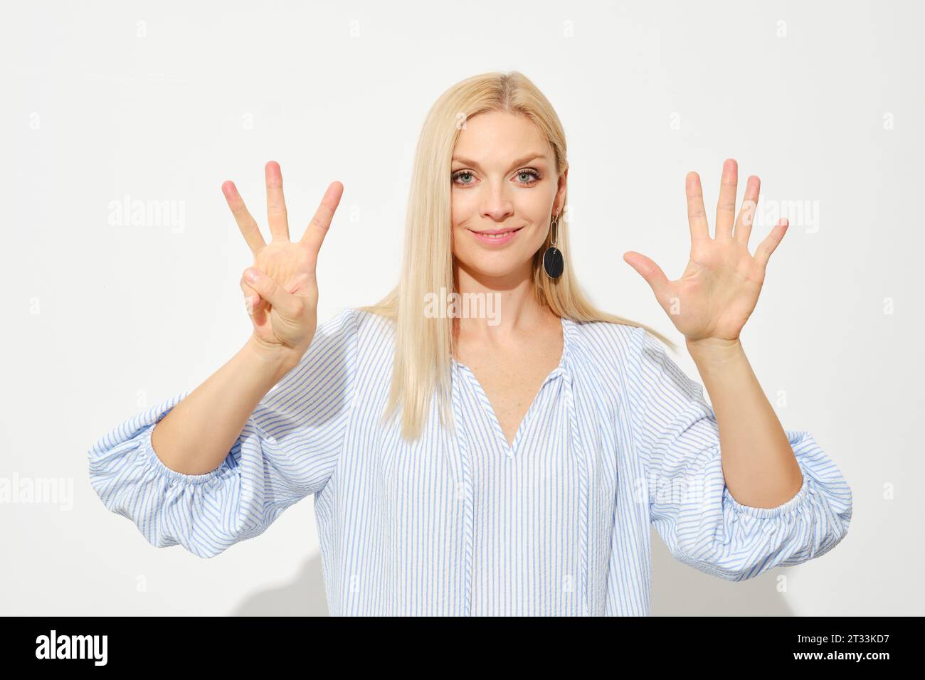 Attractive blonde woman shows eight fingers. Counting with fingers ...